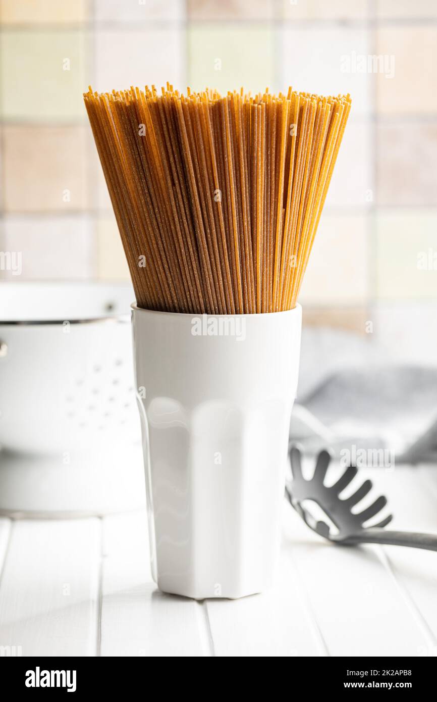 Uncooked whole grain spaghetti. Raw pasta in cup Stock Photo - Alamy