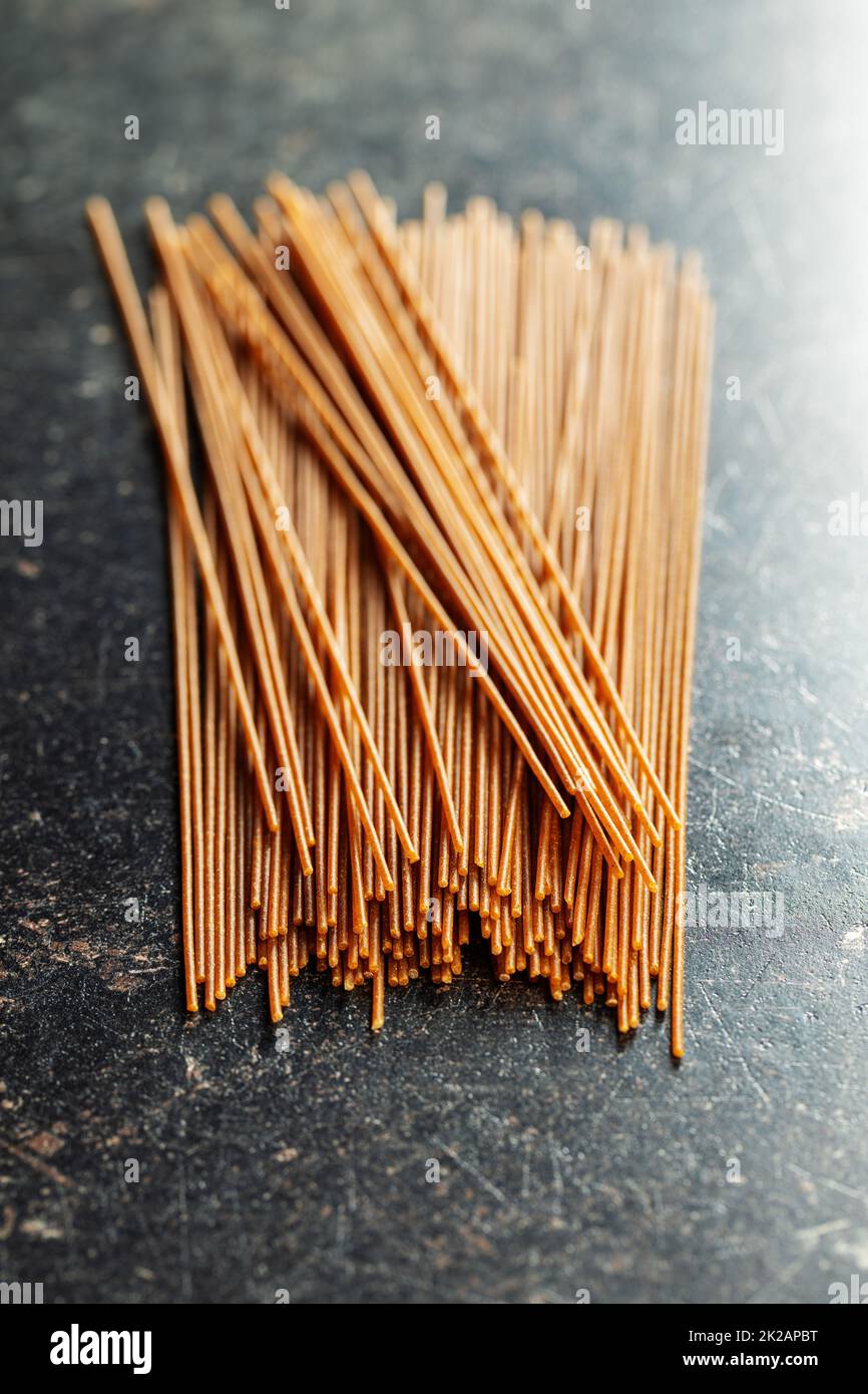 Uncooked whole grain spaghetti. Raw pasta on kitchen table Stock Photo ...