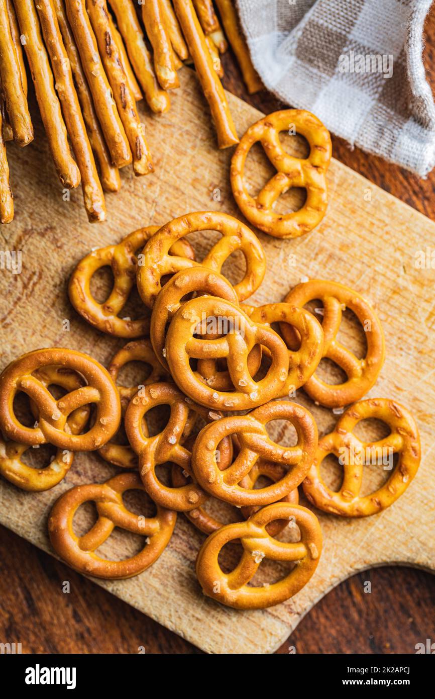 Mini pretzels and salted sticks. Crusty salted snack on cutting board ...