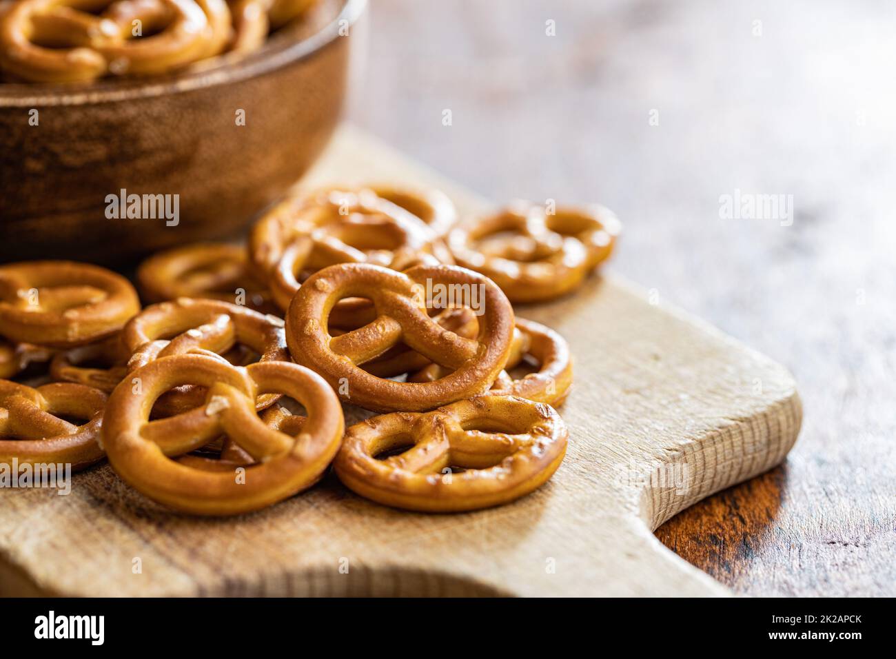 Mini pretzels. Crusty salted snack on cutting board Stock Photo - Alamy