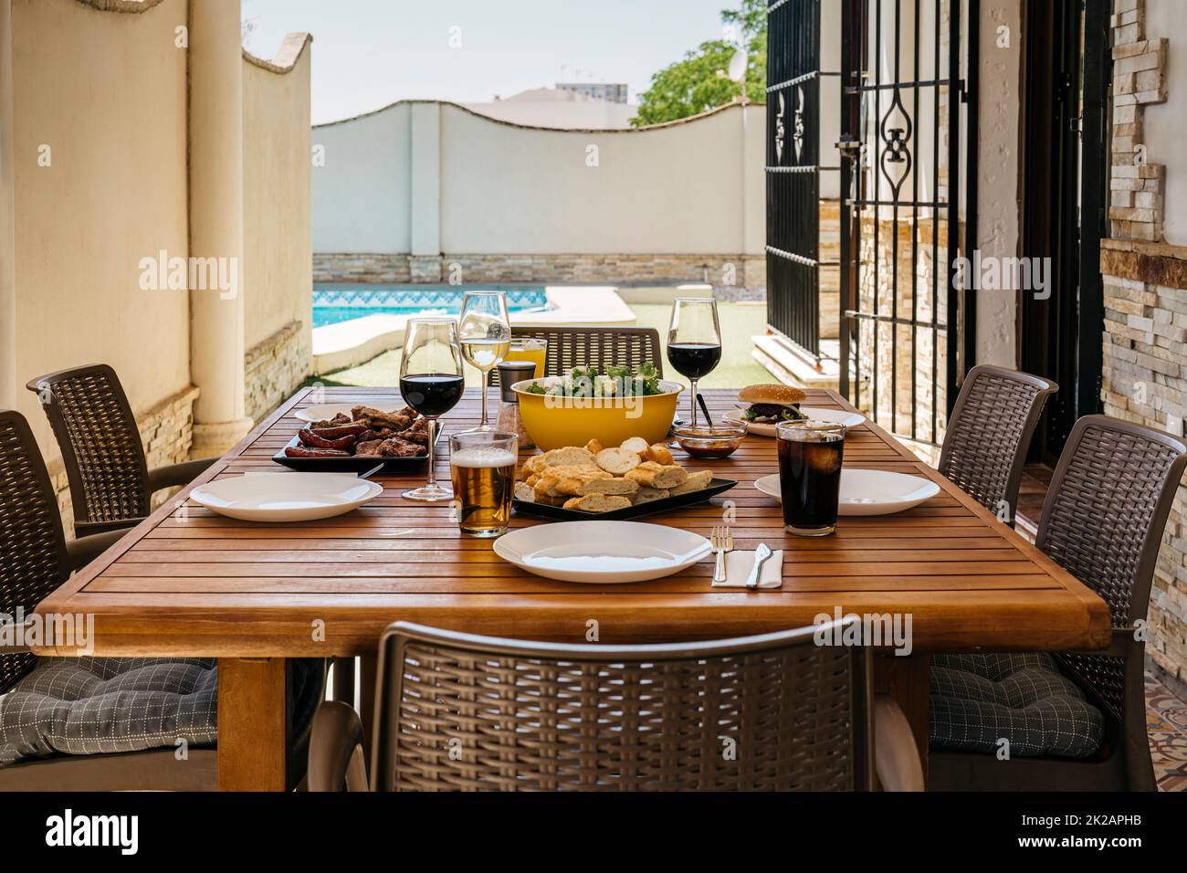 table set for a lunch with friends in a house with a swimming pool ...
