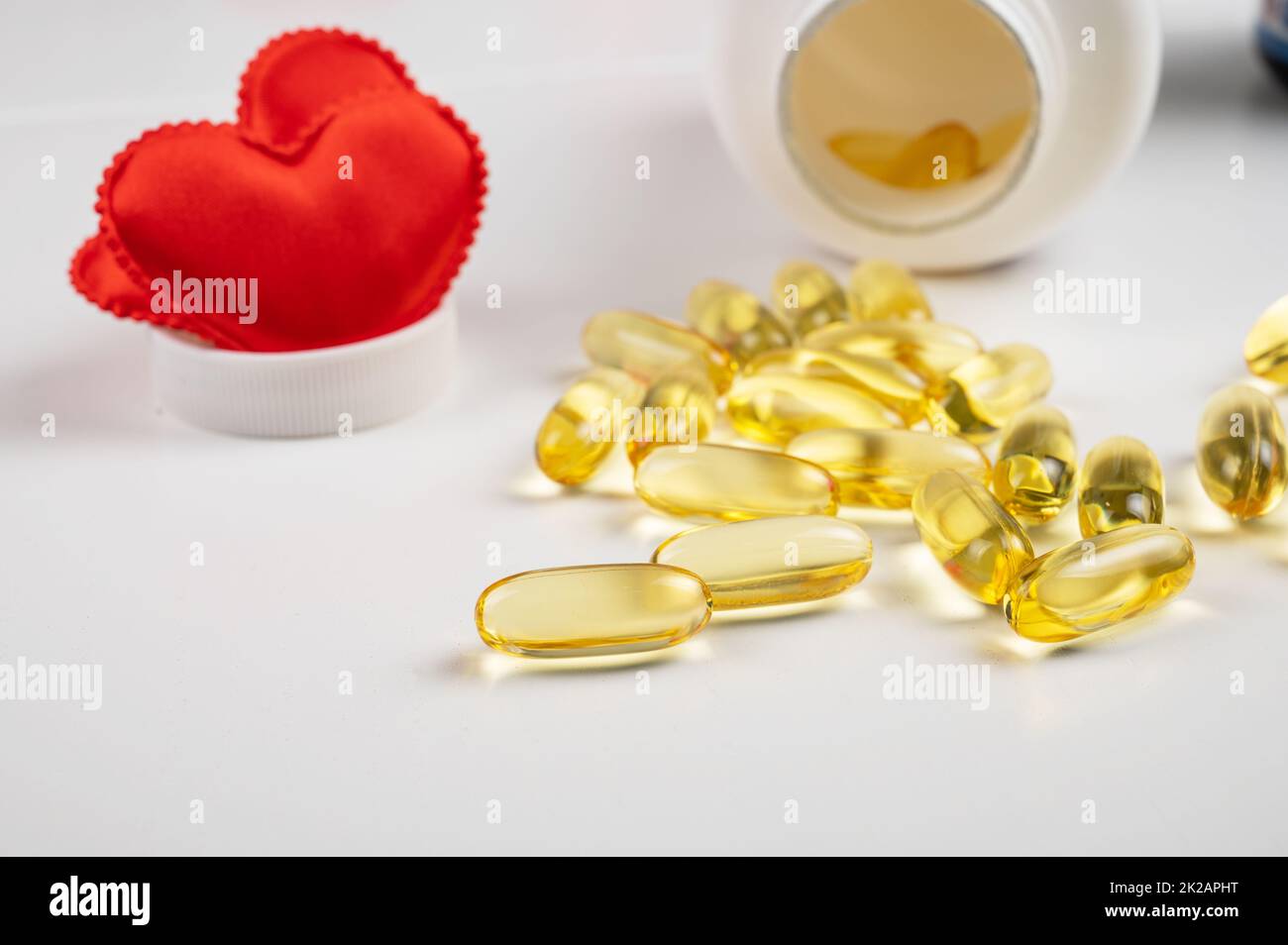 Gold fish oil isolated on white background with red hearts Stock Photo ...