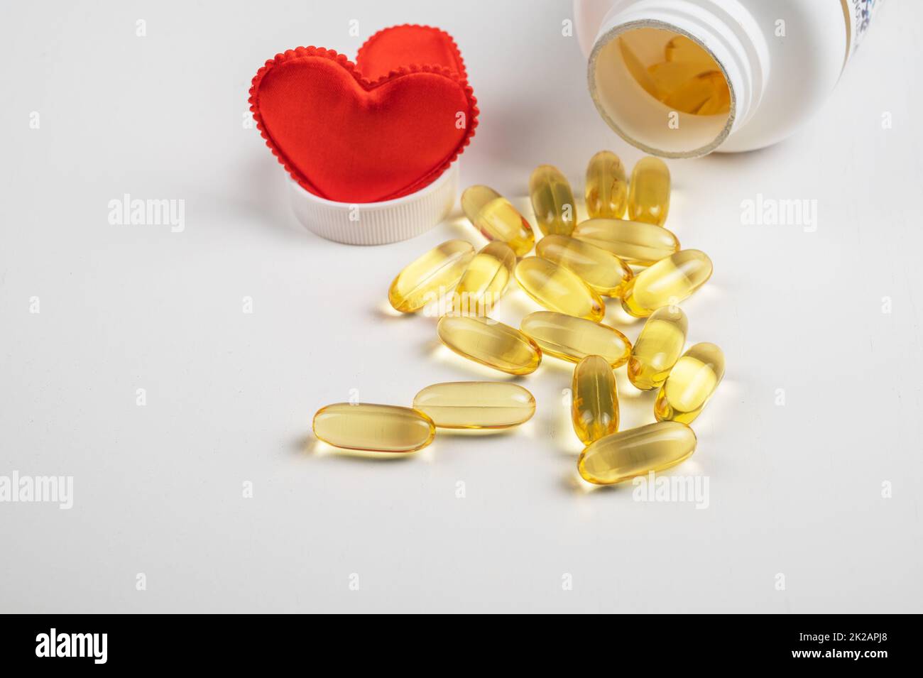 Gold fish oil isolated on white background with red hearts Stock Photo ...