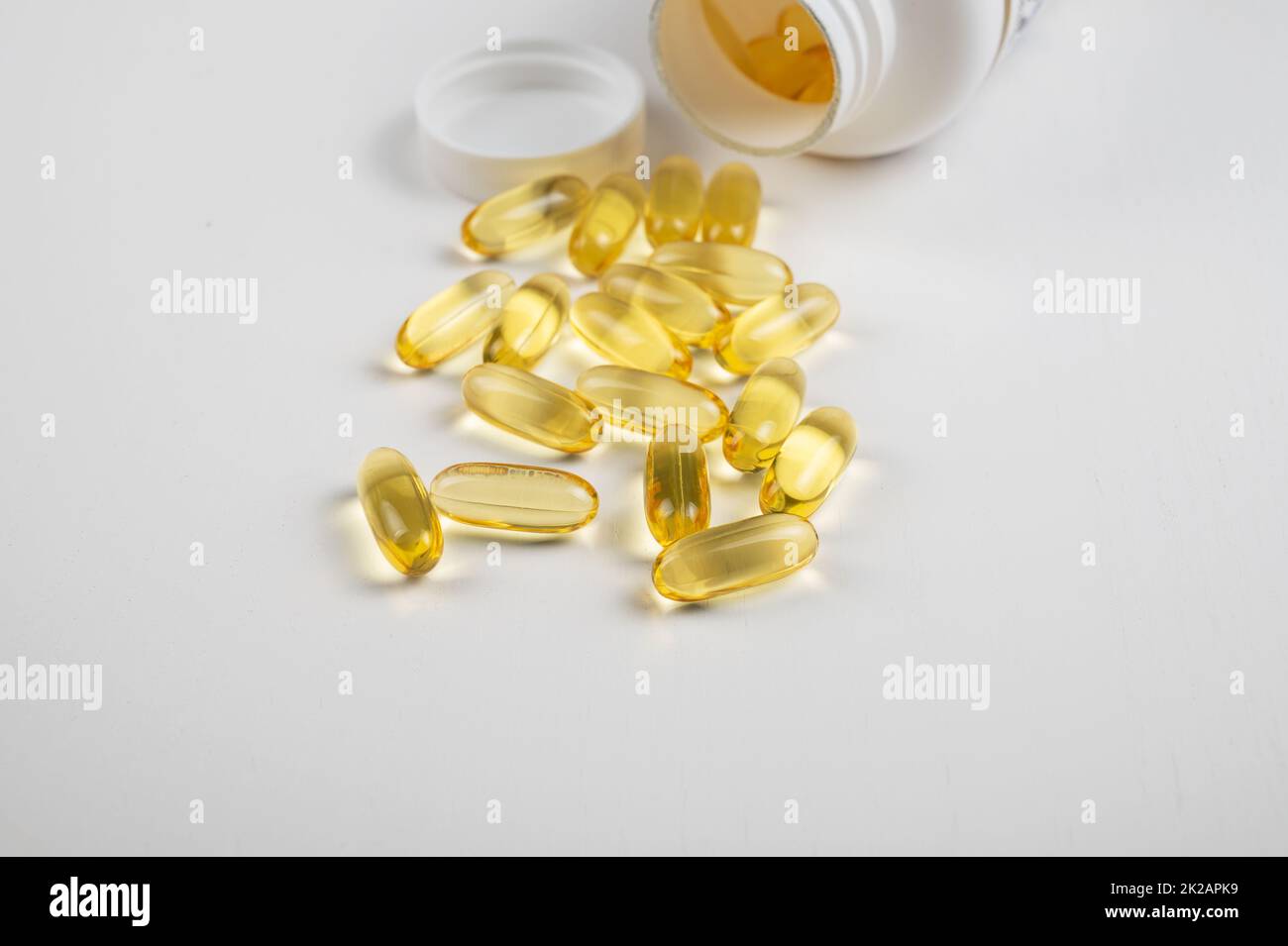 Gold fish oil isolated on white background Stock Photo - Alamy