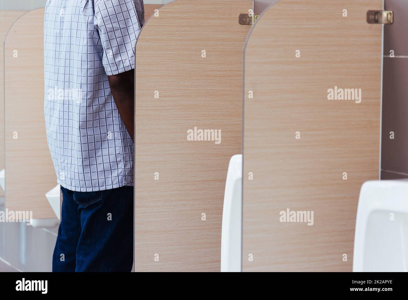 man peeing in male toilet urinals Stock Photo - Alamy