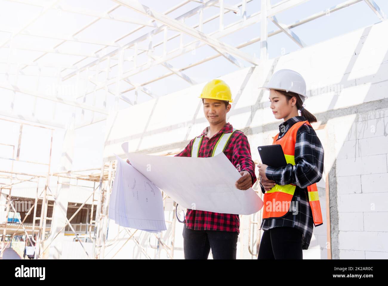 Architect and client discussing the plan with blueprint of the building ...