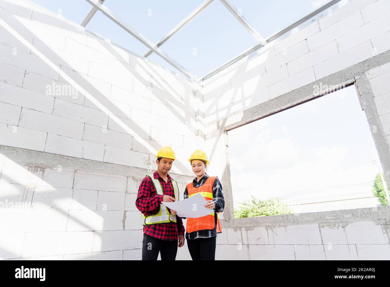 Architect and client discussing the plan with blueprint of the building ...