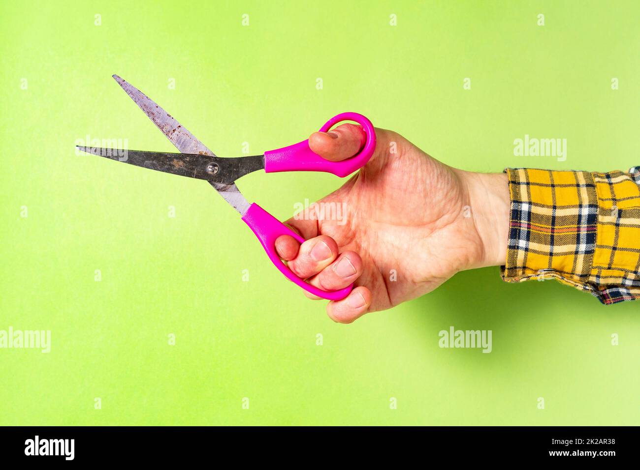 Hand holds old scissors on green background Stock Photo - Alamy
