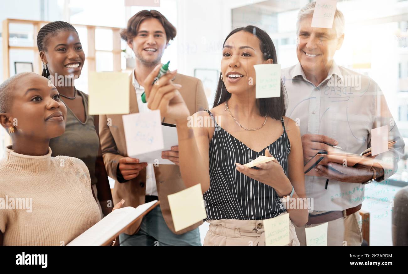 Team of workers in office, brainstorming together and writing idea on ...