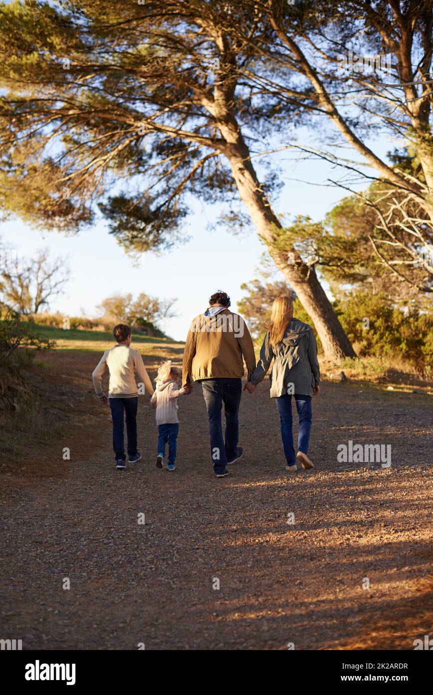 Together through adversity. Rear view shot of a happy family out on a ...