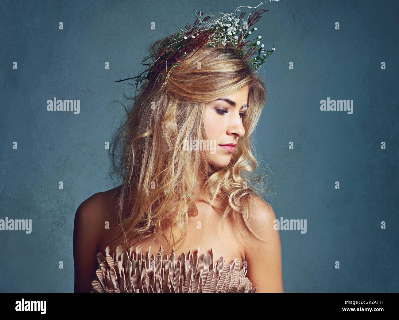 Enchanted beauty. a young woman posing with flowers in her hair against ...