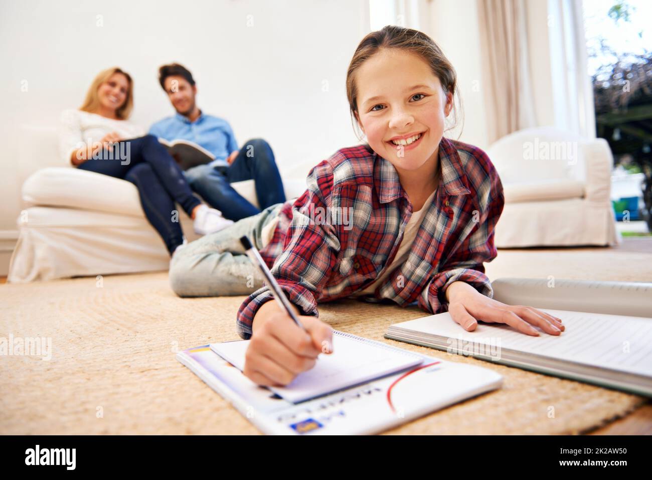 Homework done equals relaxing time. a little girl lying on the living ...