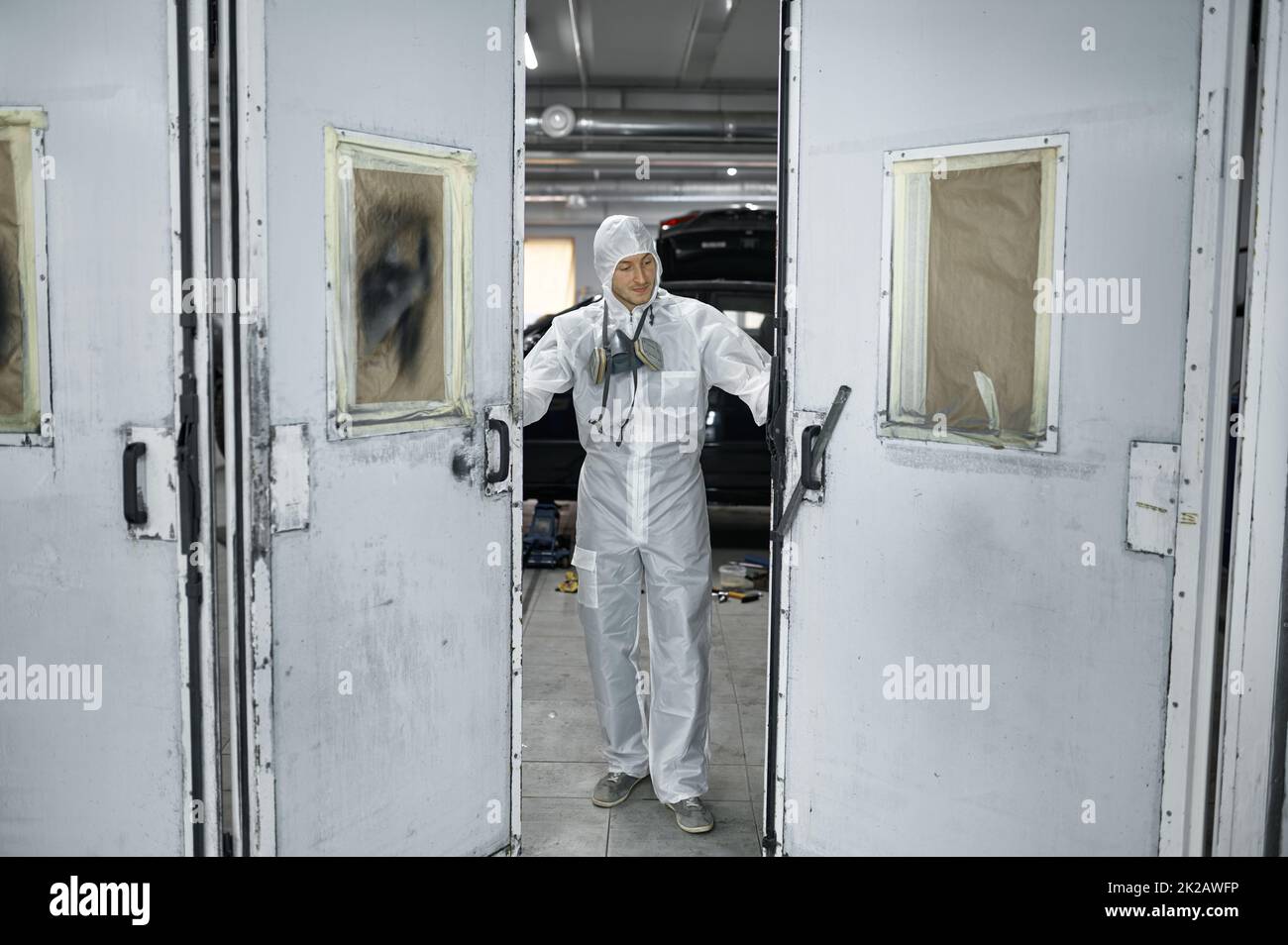 Automobile painter opening door to paint chamber Stock Photo - Alamy