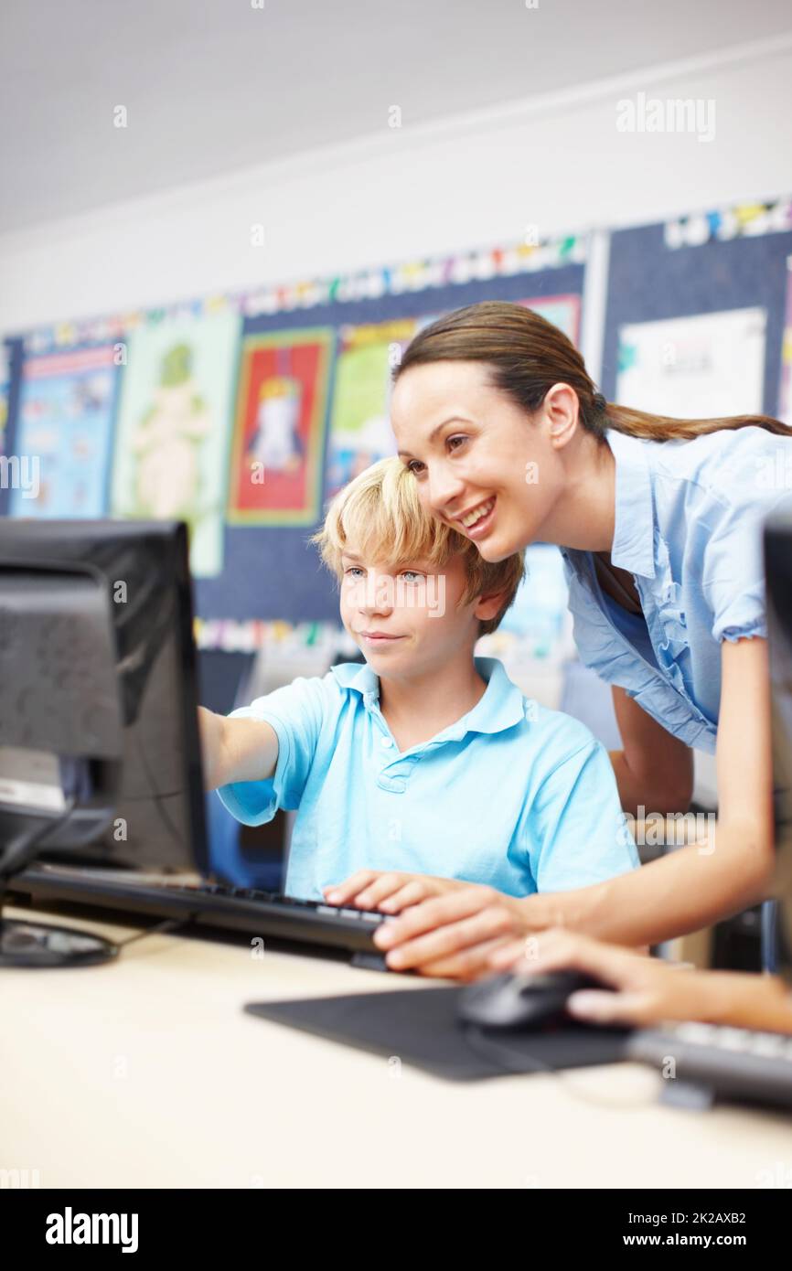 Asking questions in computer class. An attractive young teacher ...