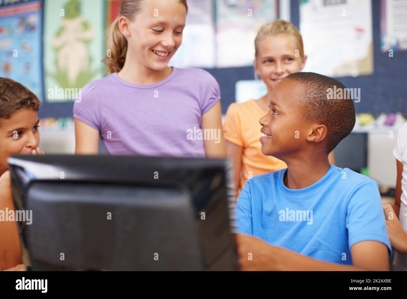 Friends in computer class. A group of cute school kids sitting and ...