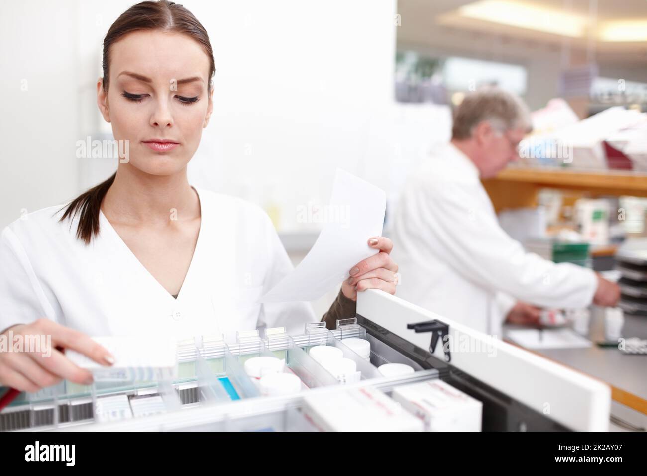 Pharmacist checking medicines with colleague. Portrait of female ... Pharmacist checking medicines with colleague. Portrait of female ...