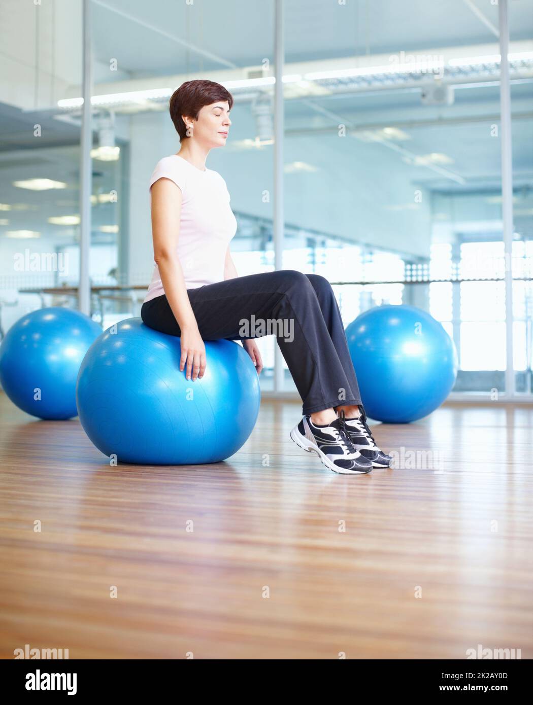 Relaxation. Full length of a fit woman sitting on pilates ball and ...