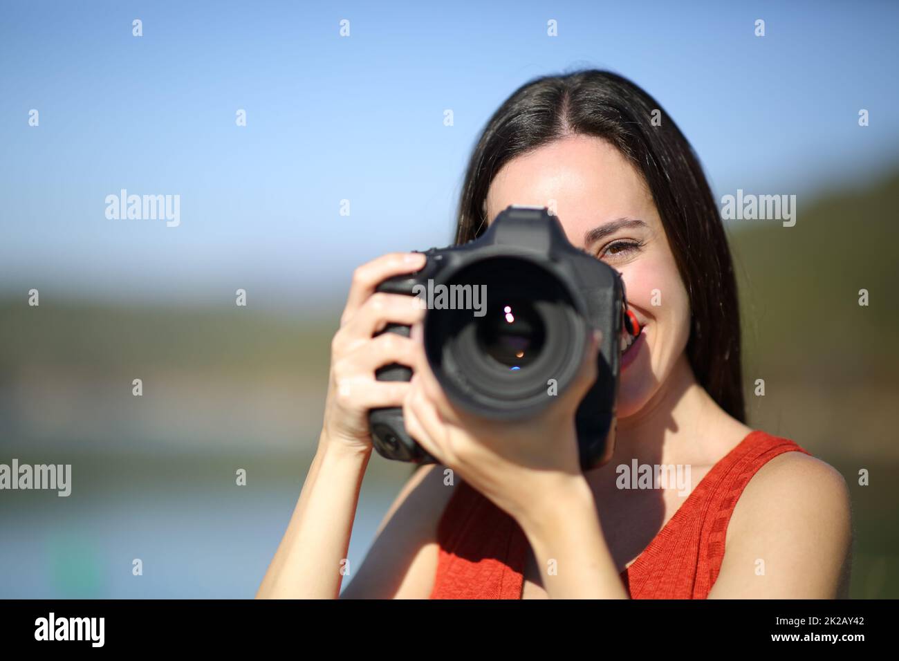 Happy woman taking photos with dslr camera in nature Stock Photo - Alamy