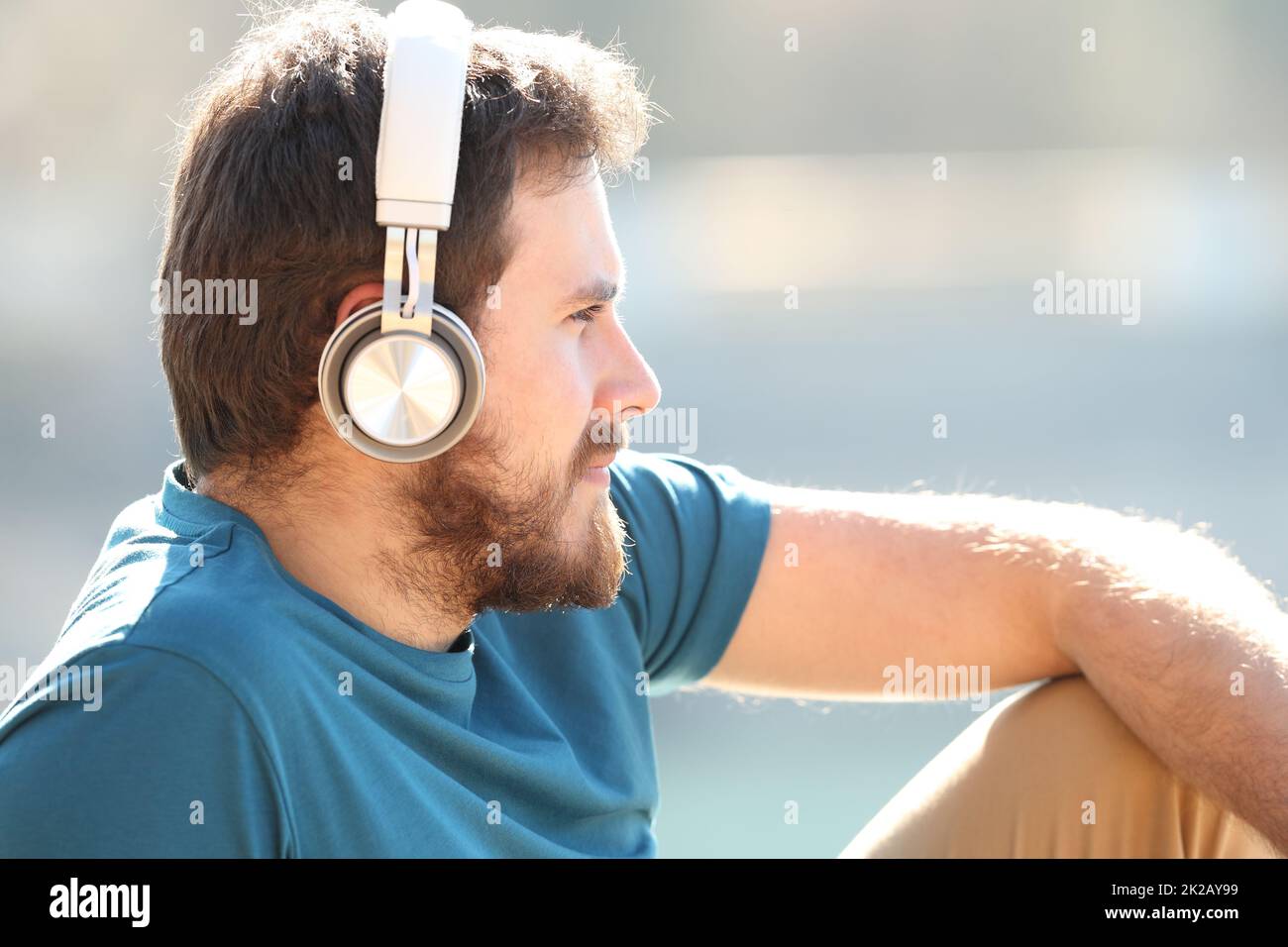 Man relaxing and looking listening to music outdoors Stock Photo - Alamy