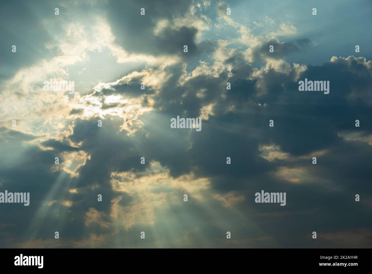 The sun behind the clouds and the sun's rays Stock Photo - Alamy