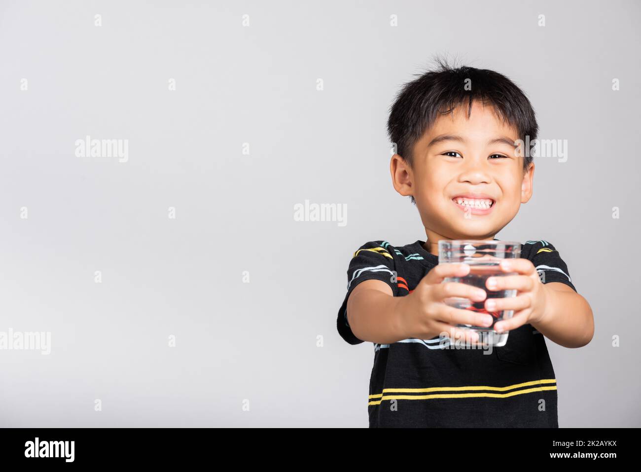 Little cute kid boy 5-6 years old smile drinking fresh water from glass ...