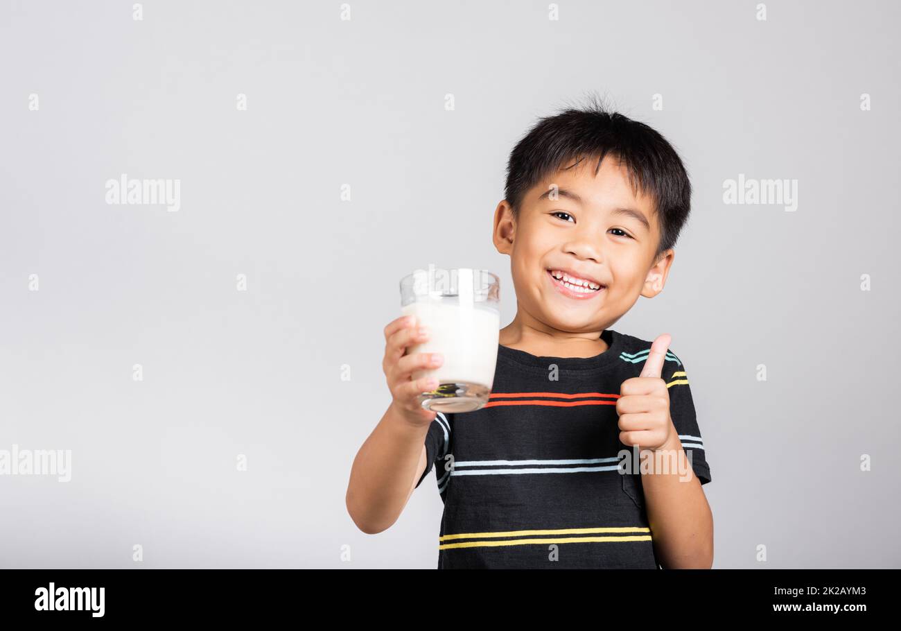 Little kid boy 5-6 years old smile holding milk glass he drinking white ...