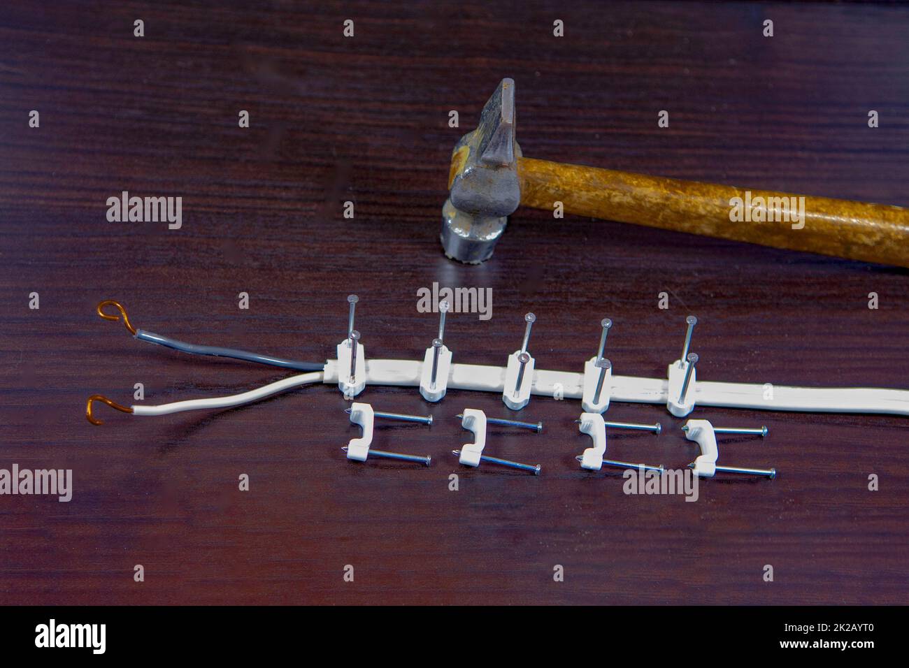 Fastening clips for electrical wires and a hammer Stock Photo - Alamy