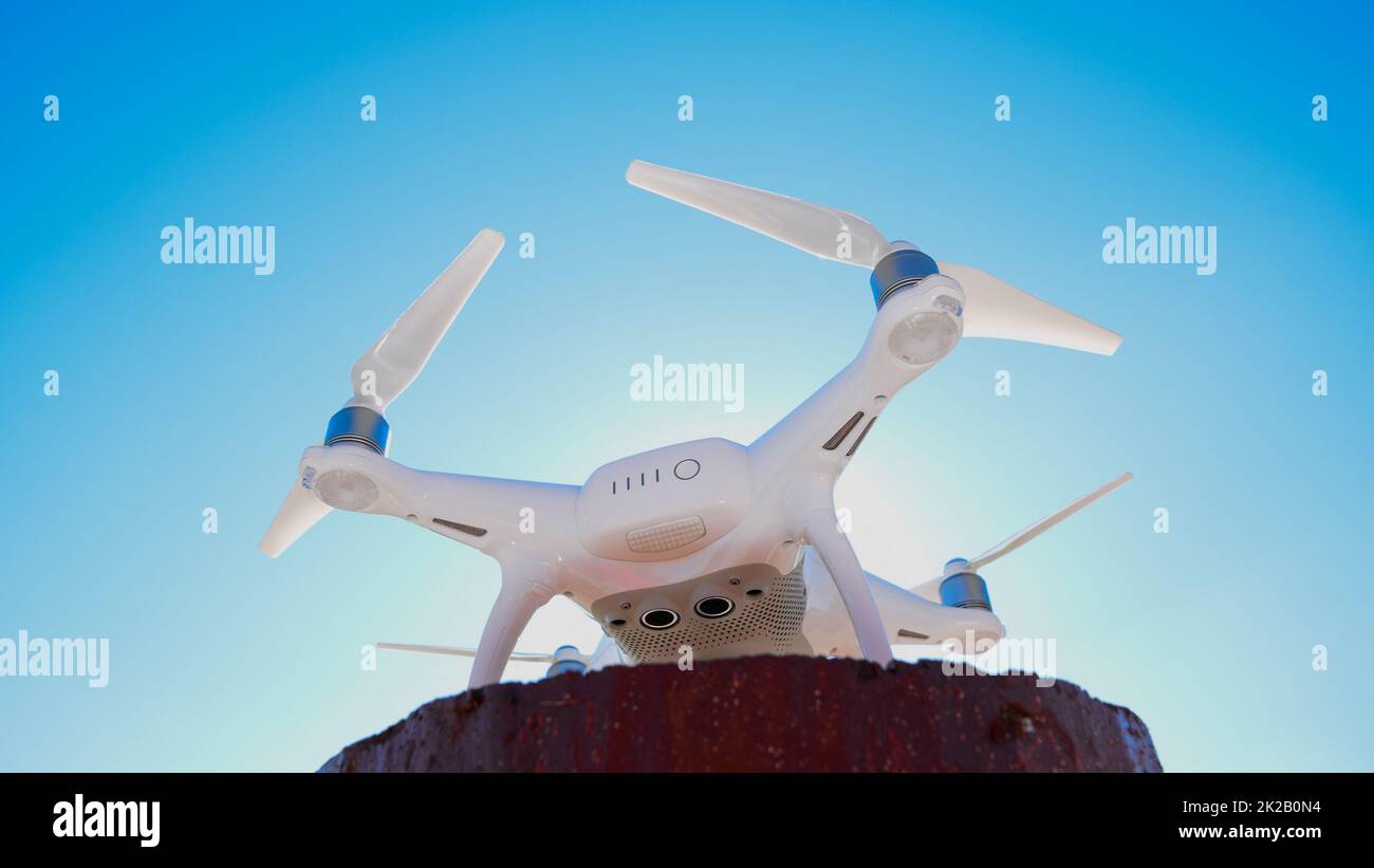 Quadrocopter Phantom 4 against the blue sky in the sun. Backlight. Dron ...
