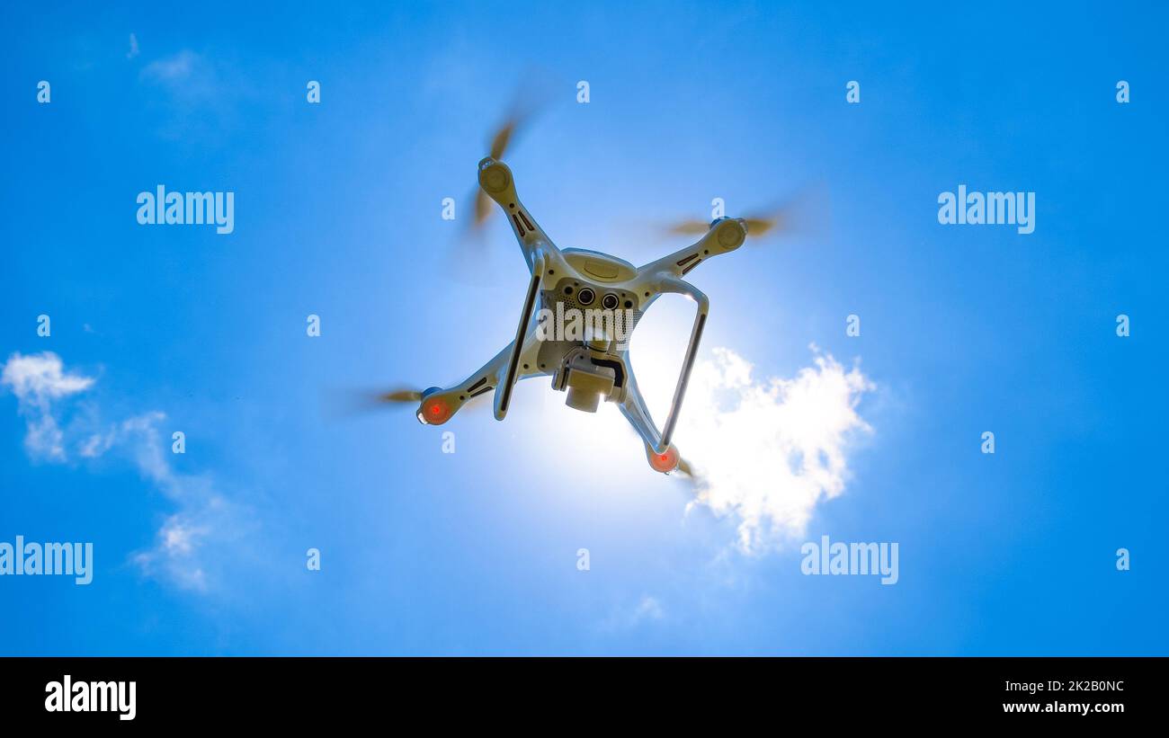 Drone DJI Phantom 4 in flight. Quadrocopter against the blue sky Stock ...