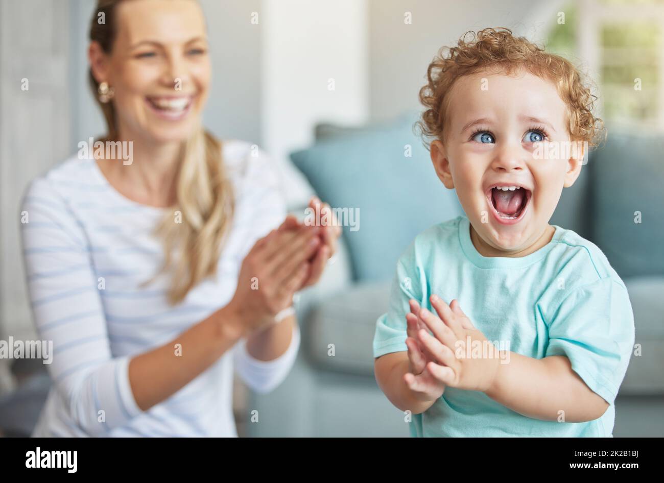 Happy, clapping hands and mother and son playing in the living room of ...