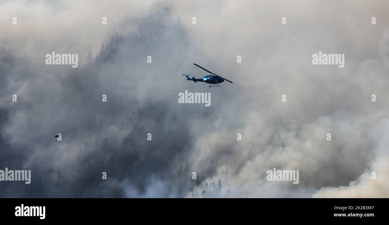 Wildfire Service Helicopter flying over BC Forest Fire and Smoke on the ...