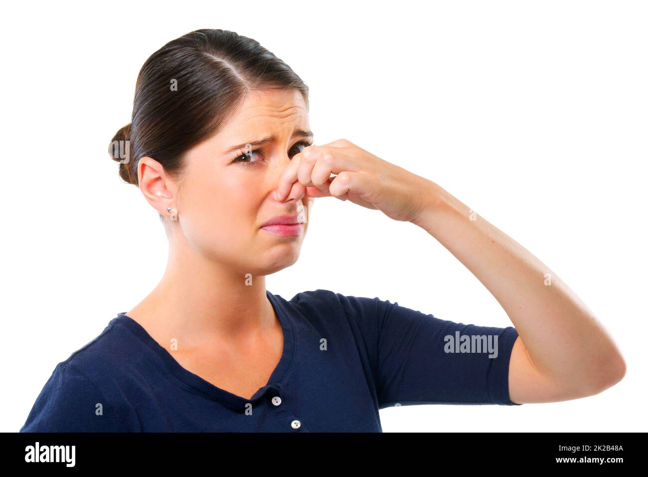 Gross. Studio shot of a young woman holding her nose isolated on white ...