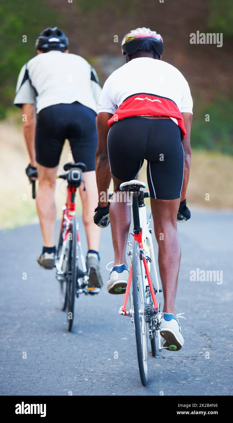Trying to pass the leader. Rearview shot of two riders cycling down a ...