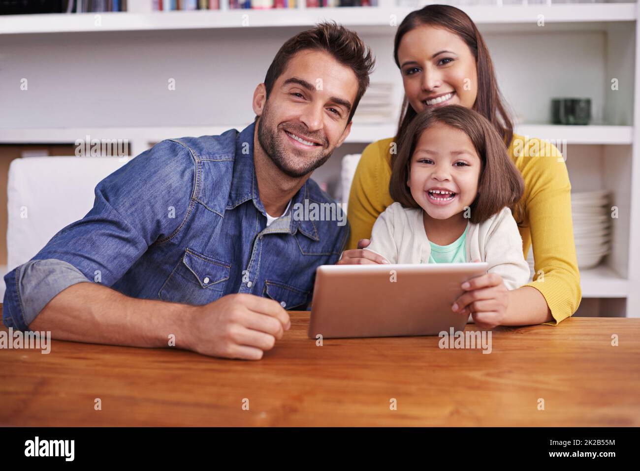 Life is about family and technology. young parents showing their little ...