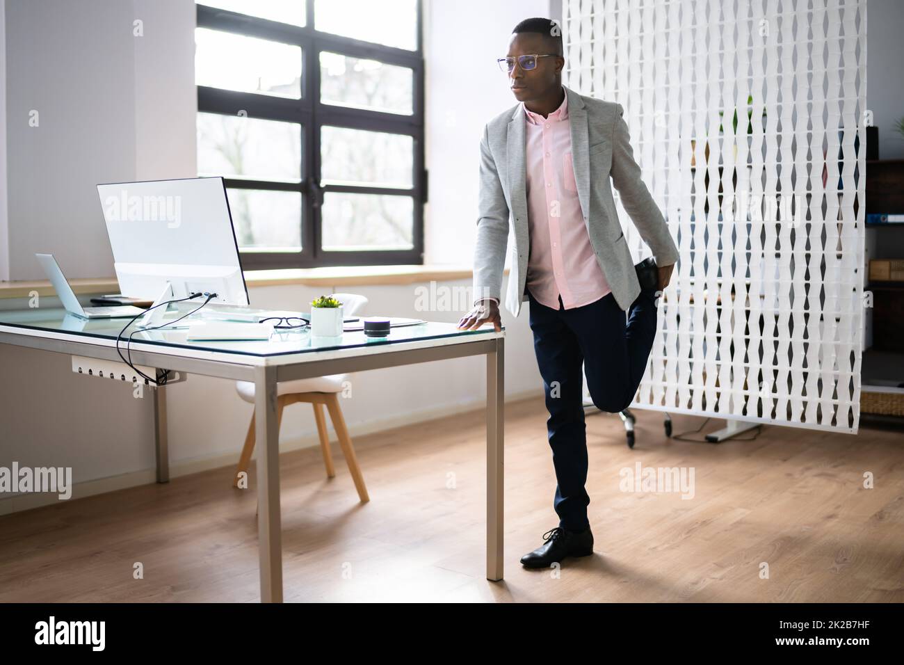 Yoga Workout In Office Behind Business Computer Stock Photo - Alamy
