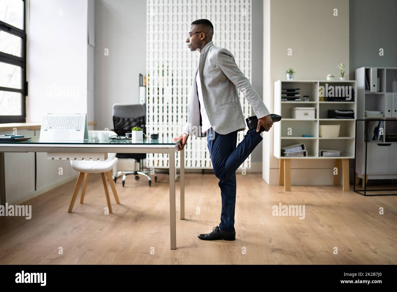 Yoga Workout In Office Behind Business Computer Stock Photo - Alamy