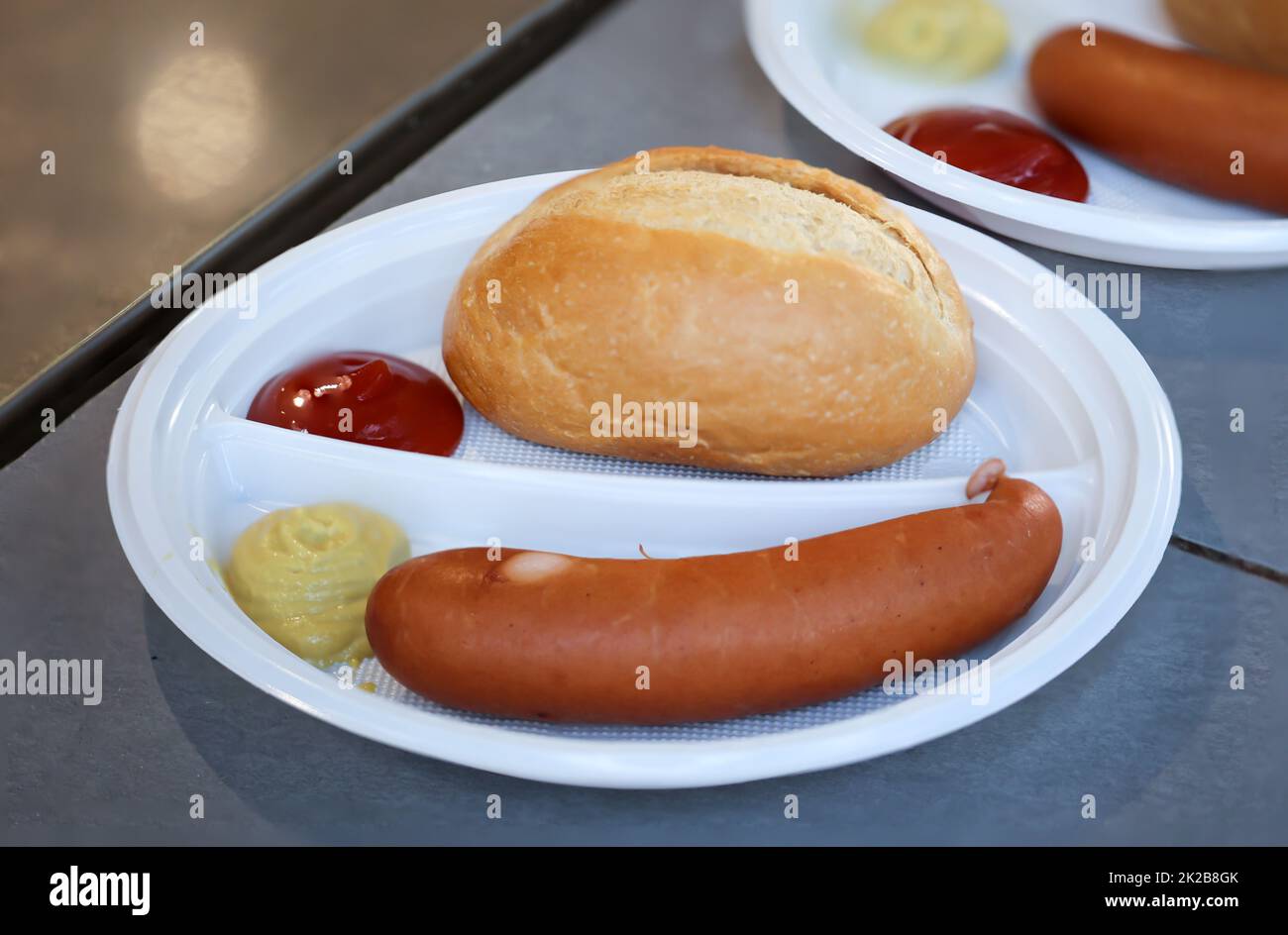 A bockwurst with a bun, ketchup and mustard on a plate Stock Photo - Alamy