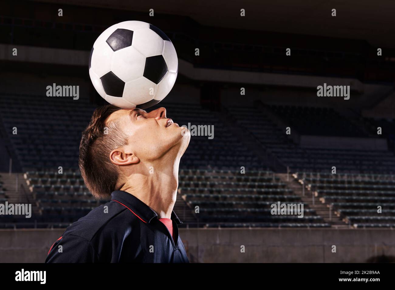 Skill and balance. Shot of a young footballer balancing a ball on his ...