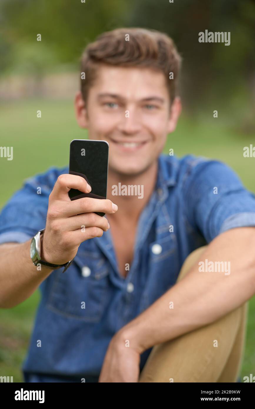 Give me a big smile. Portrait of a young man taking a picture with his ...
