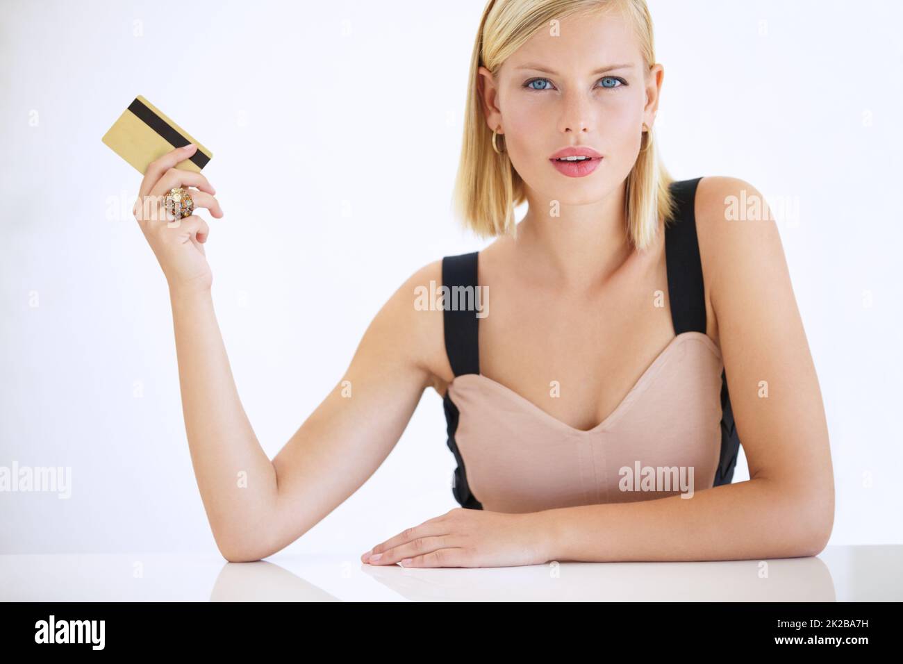 Shes a big spender. Gorgeous young woman sitting and holding a credit ... Shes a big spender. Gorgeous young woman sitting and holding a credit ...
