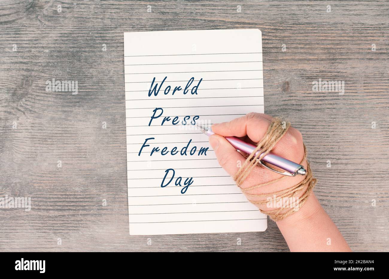 World Press Freedom Day is standing on a paper, hand with pen is ...