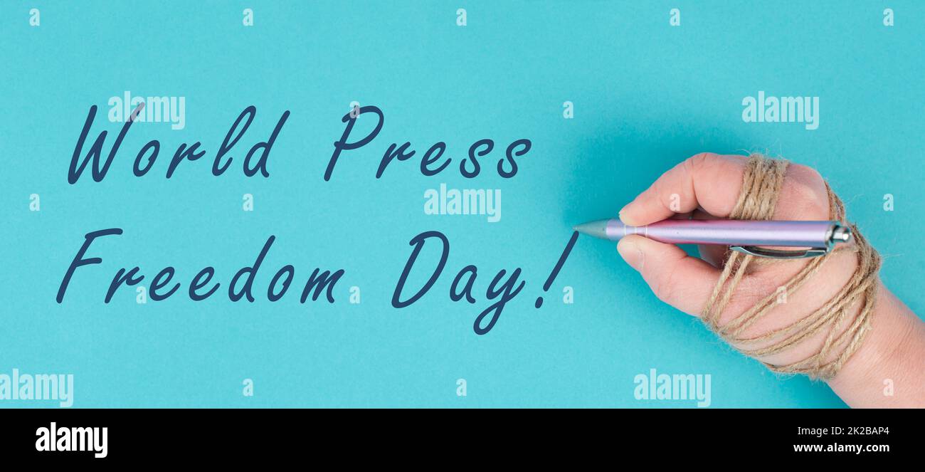 World Press Freedom Day is standing on a paper, hand with pen is ...