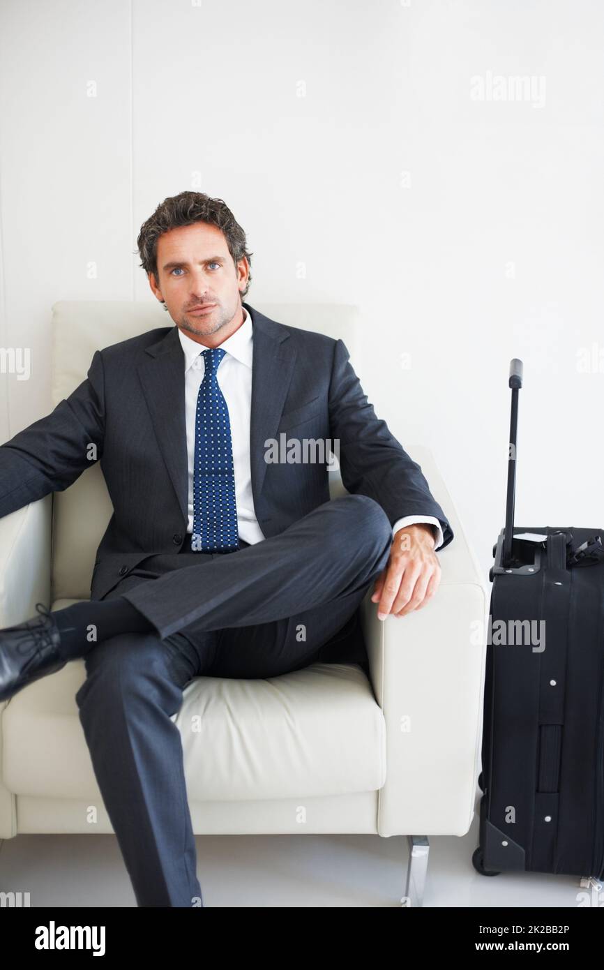 Handsome man ready for business tour. Business man sitting on a chair ...
