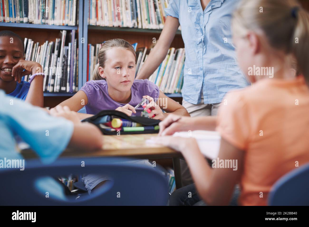 Concentrating on her work. A young girl sitting in the library with her ...