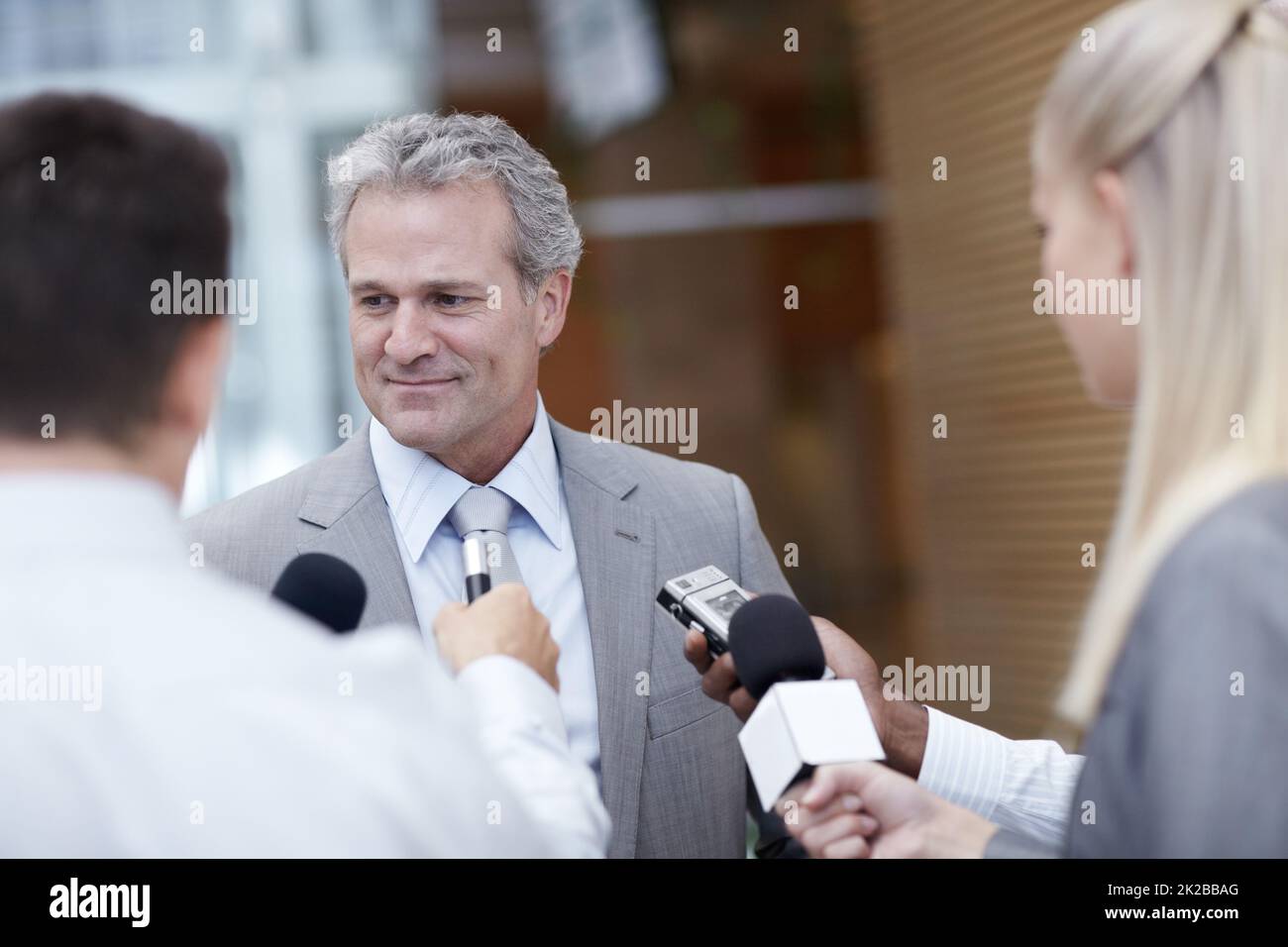 News reporters interviewing smiling man hi-res stock photography and ...