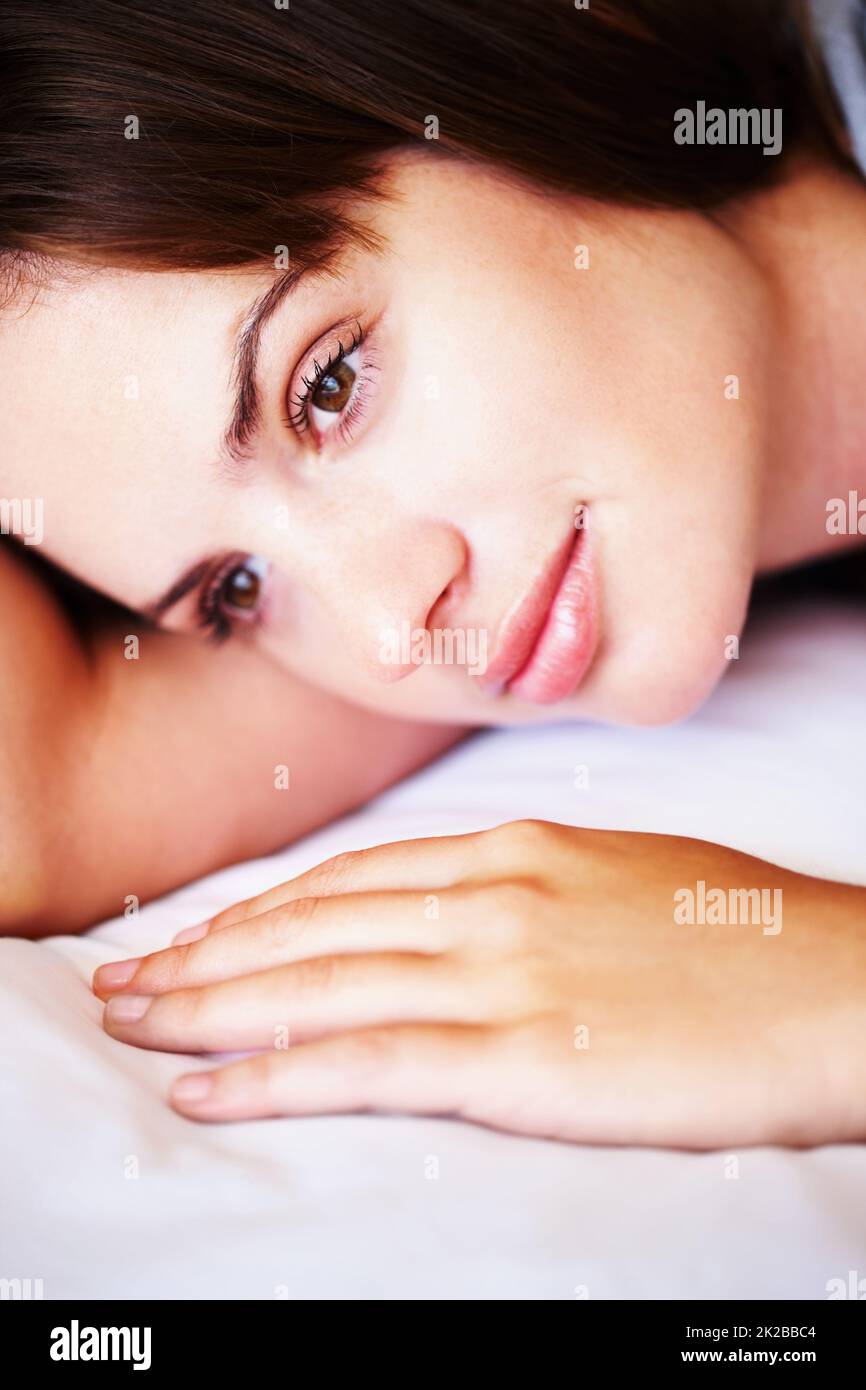 Pretty female lying peaceful in bed , lost in thought. Closeup portrait ...
