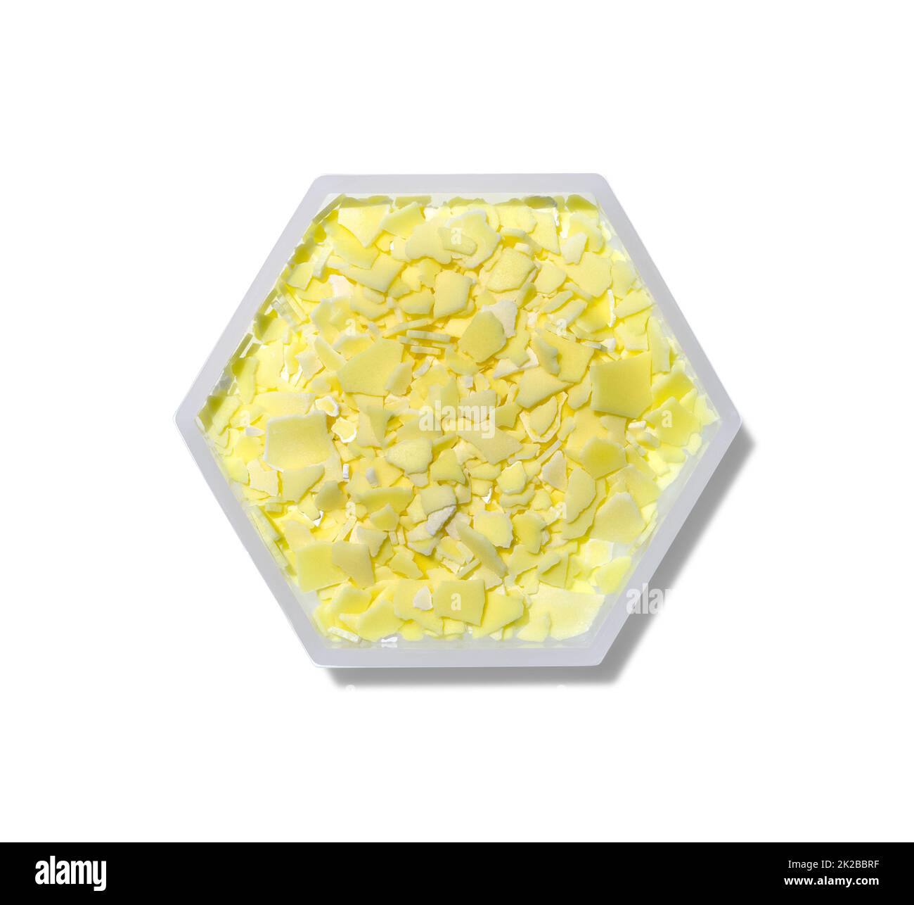 Sodium sulfide flakes in hexagonal molecular shaped container on white ...