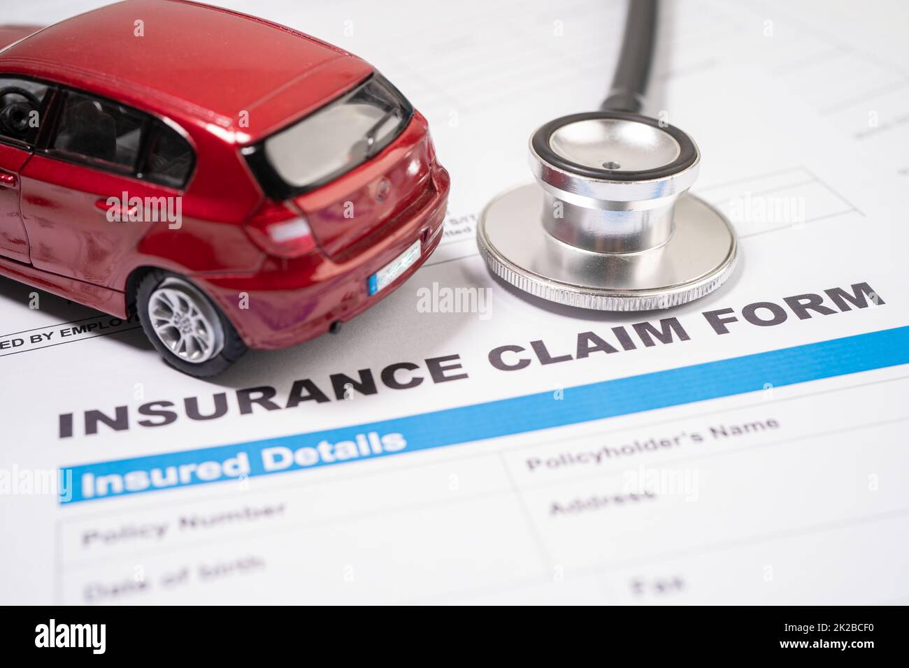 Stethoscope with red car on Insurance claim accident car form, Car loan ...