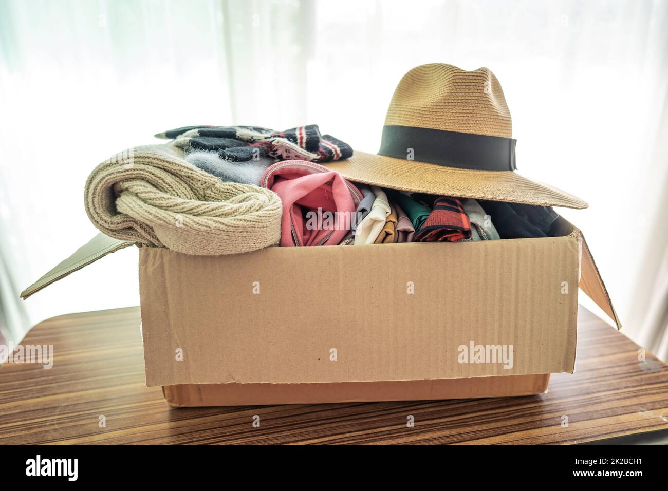 Holding clothing donation box with used clothes and hatl at home to ...
