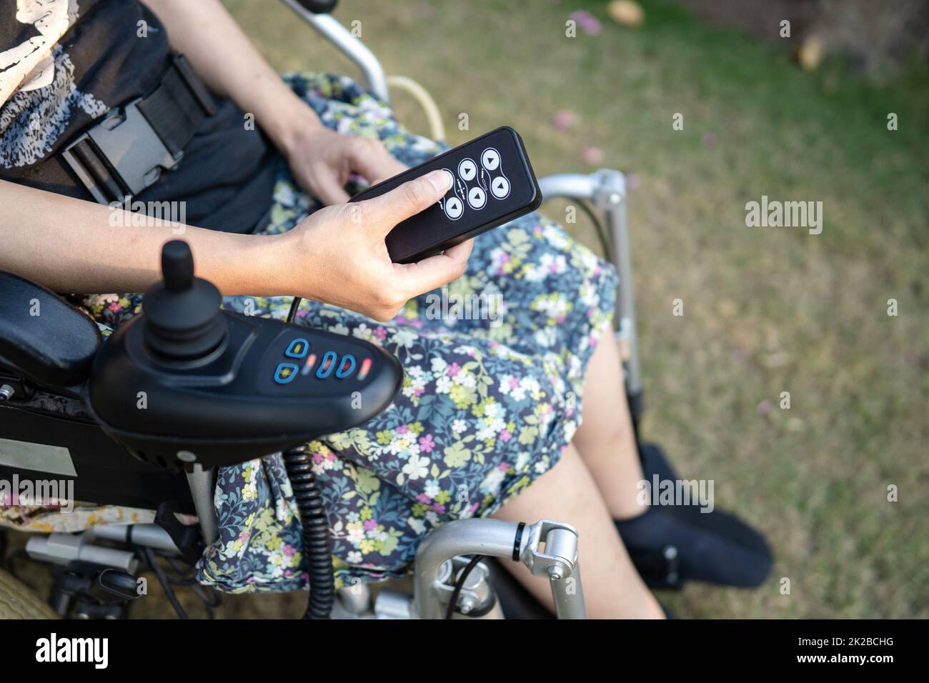 Asian lady woman patient on electric wheelchair with joystick and ...